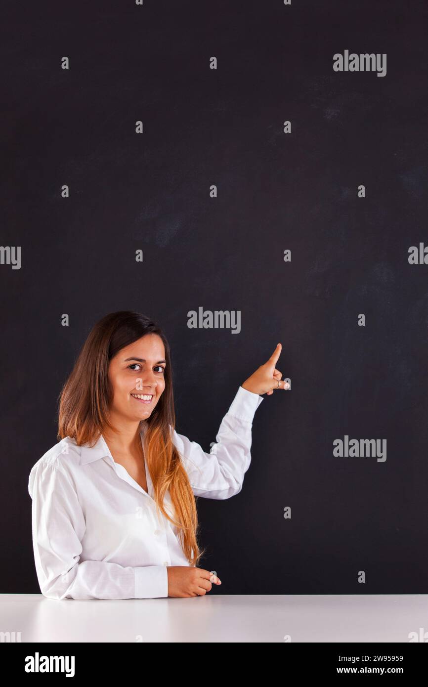 Woman pointing to the blackboard Stock Photo - Alamy