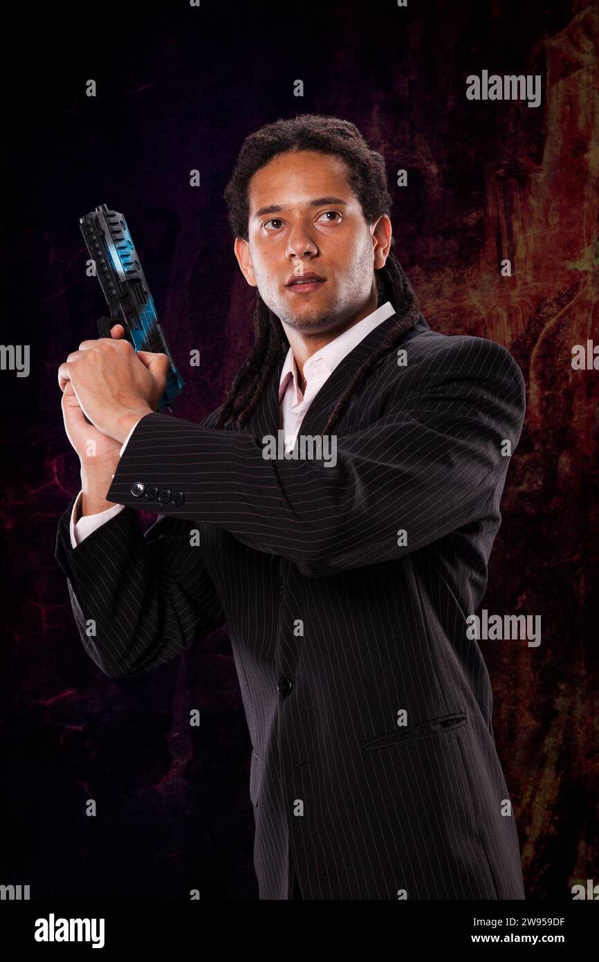 Powerful young man with a gun Stock Photo - Alamy