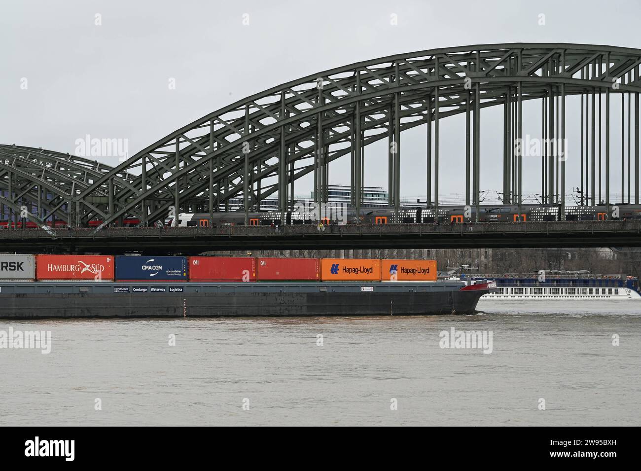 Ein Binnenschiff beladen mit Containern bei Hochwasser auf dem Rhein ...