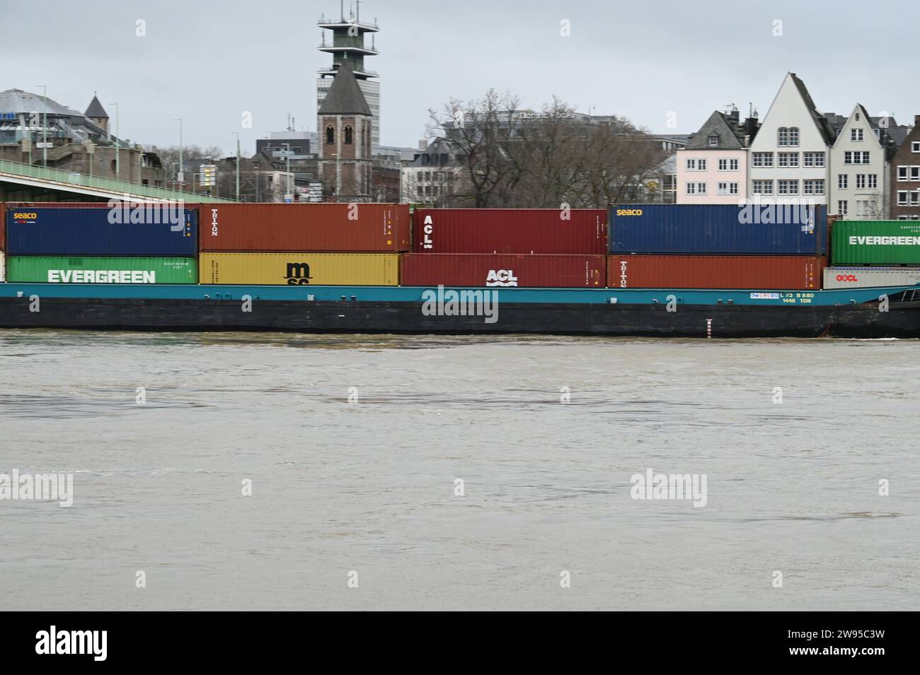 Ein Binnenschiff beladen mit Containern bei Hochwasser auf dem Rhein ...