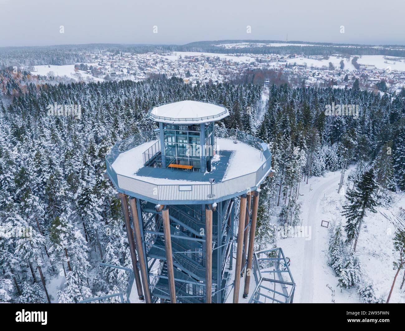 Modern observation tower rises out of a snow-covered forest ...