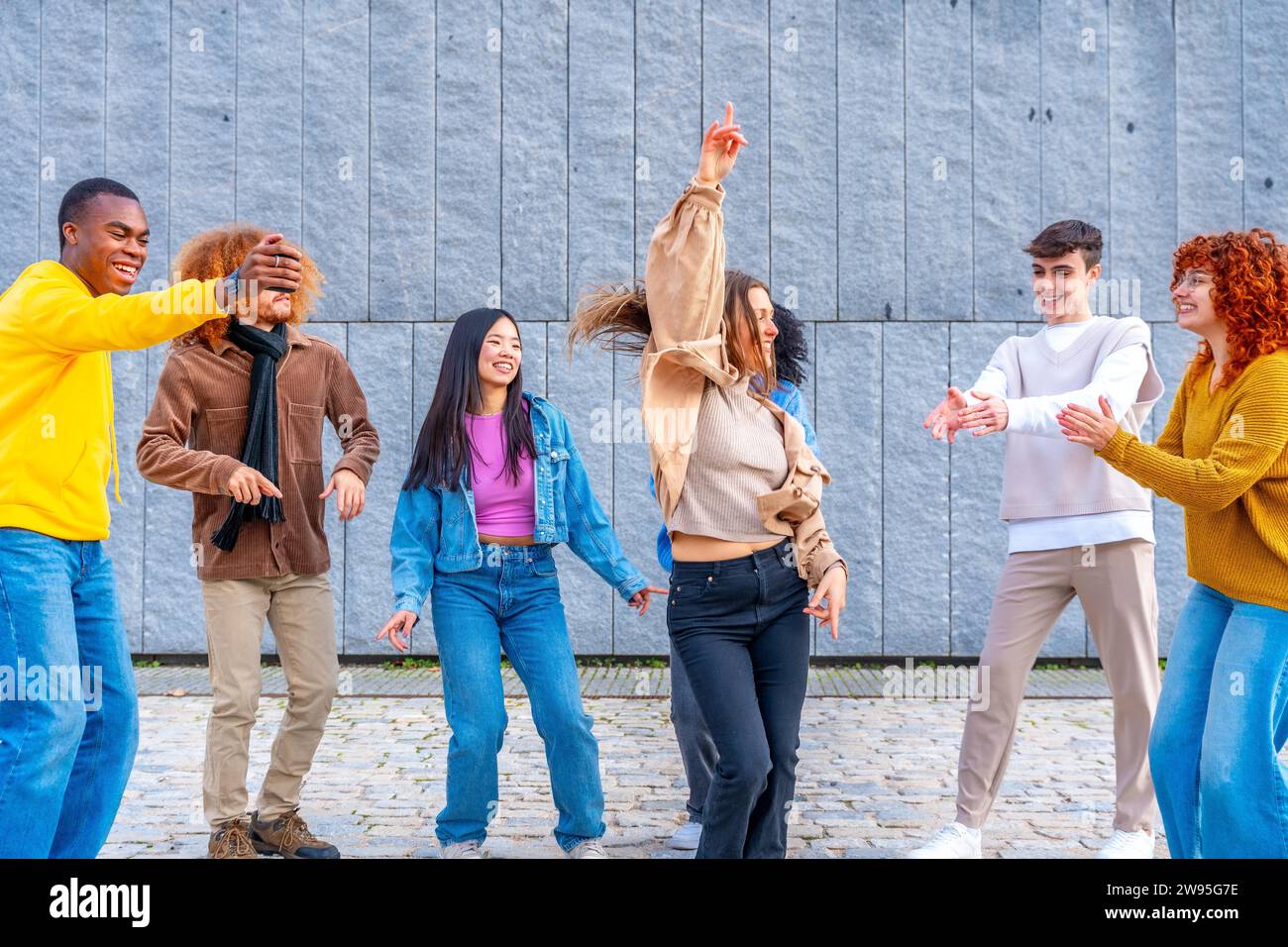 Woman dancing raising arms in the middle of multi-ethnic friends in the ...