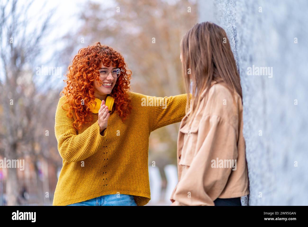 Side view of two smiling women chatting standing in the street Stock ...
