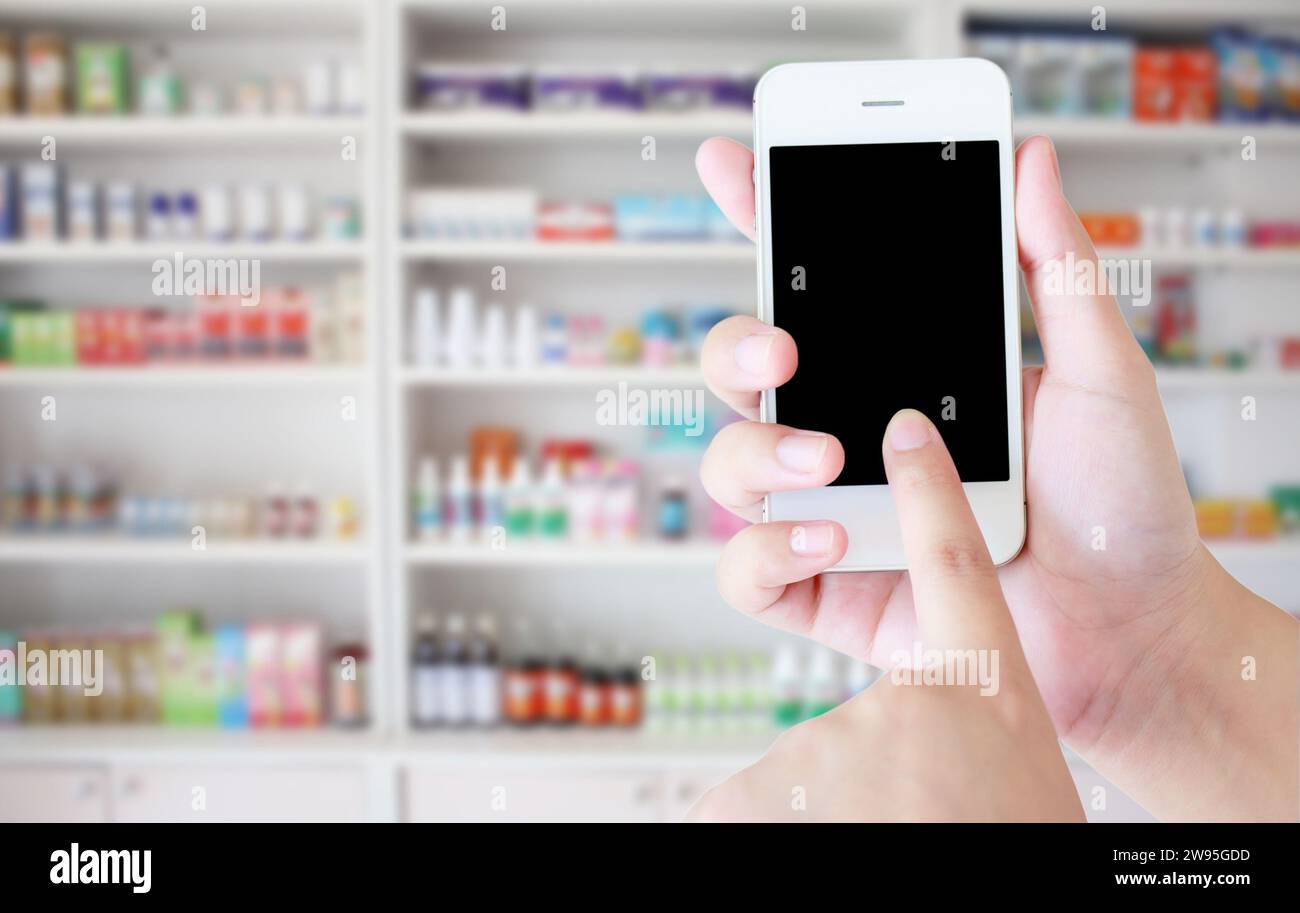 hand using smartphone with blur shelves of drugs in the pharmacy Stock ...
