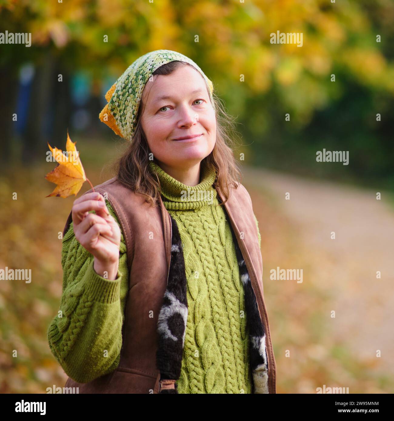 Portrait of woman in autumn park with yellow maple leaf. Portrait of a ...