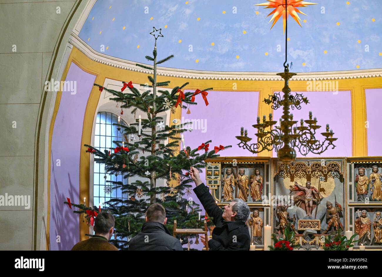 Sieversdorf, Germany. 24th Dec, 2023. Frank Schütte (r), lector, lights ...