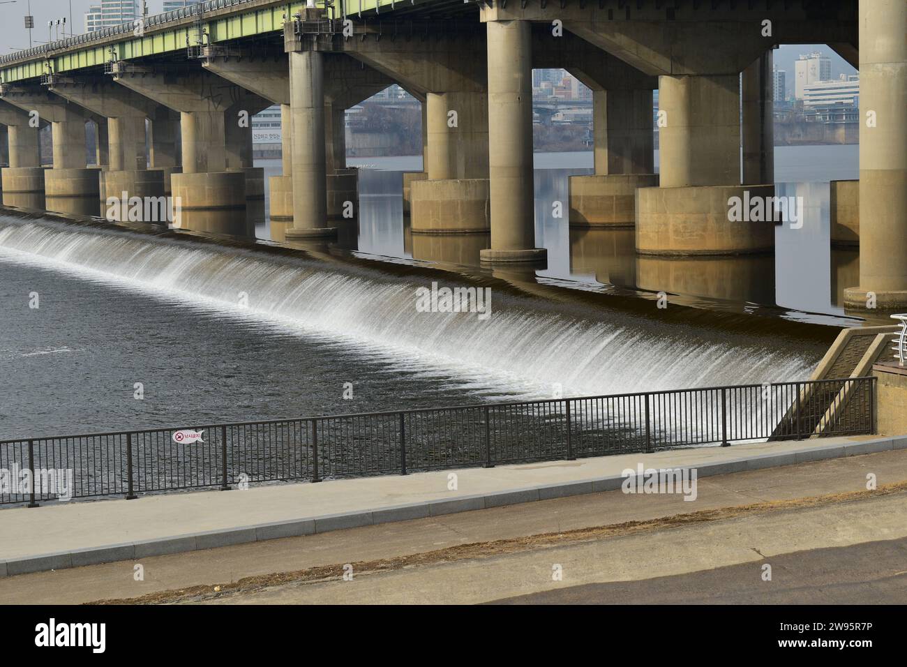 Water flowing over the free overfall spillway under the Jamsil bridge ...