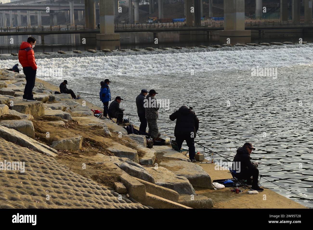 Local Korean men fishing in the turbulent water of a side river joining ...