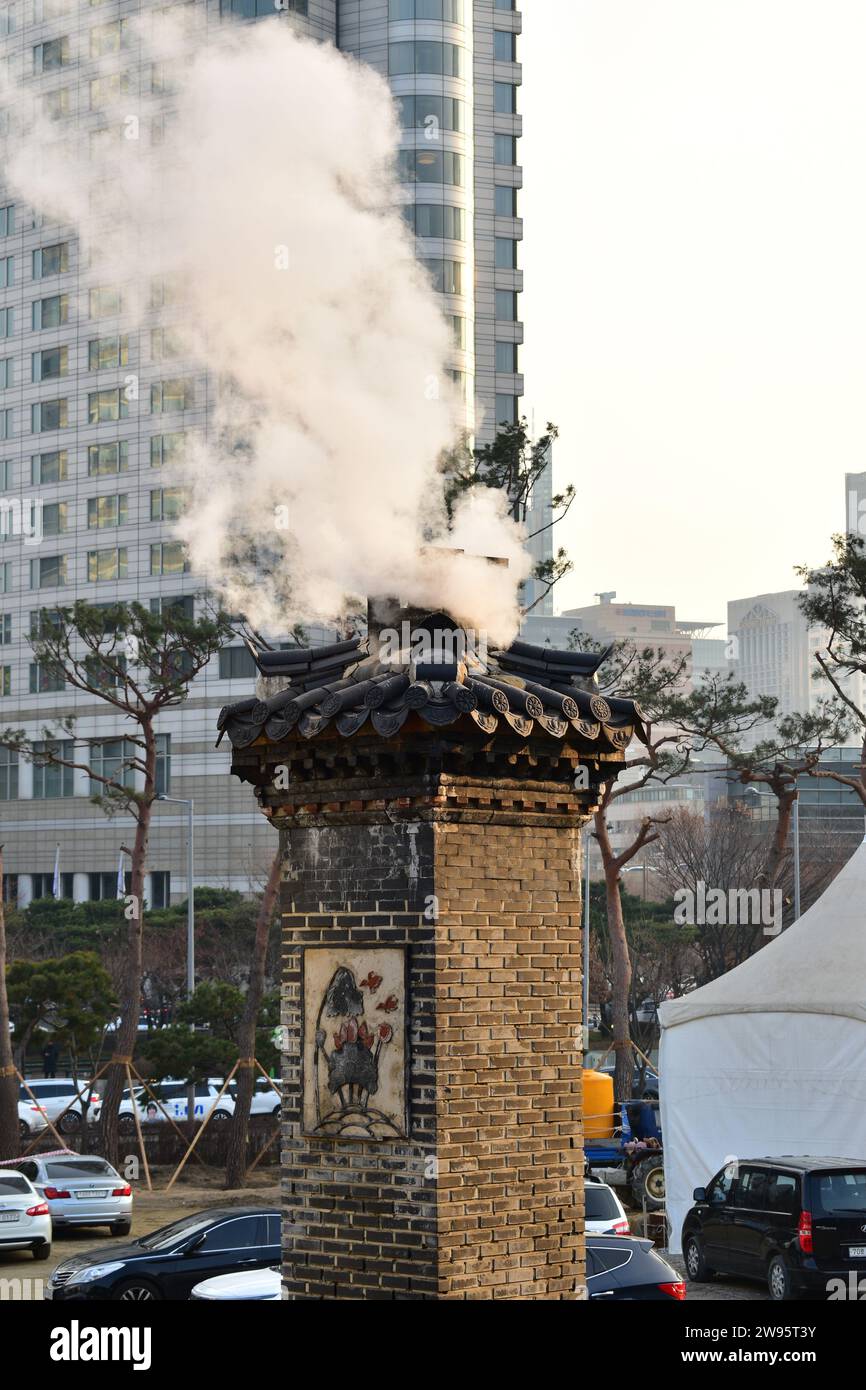 A decorated brick chimney in traditional Korean style releasing white ...