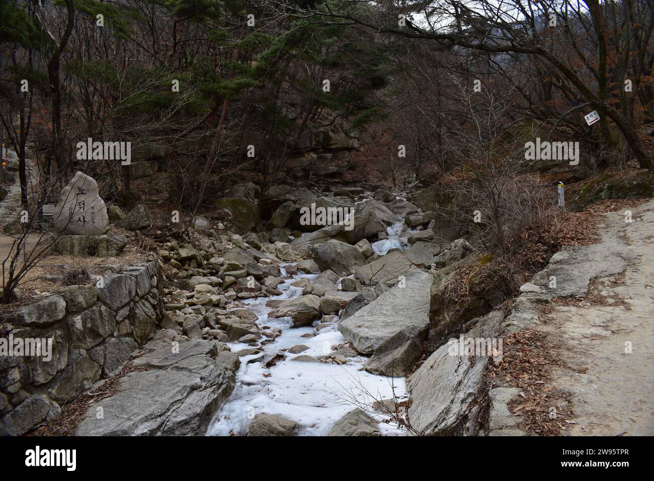 Rocky frozen river bed running along a walking trail in Bukhansan ...