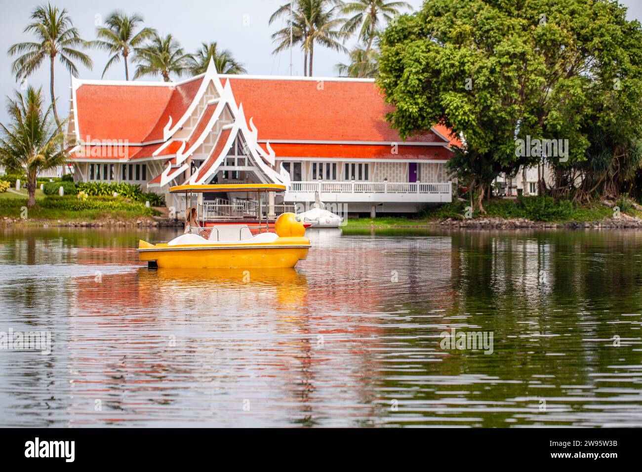 Tropical resort view with duck pedal boat on calm waters. Vacation and ...