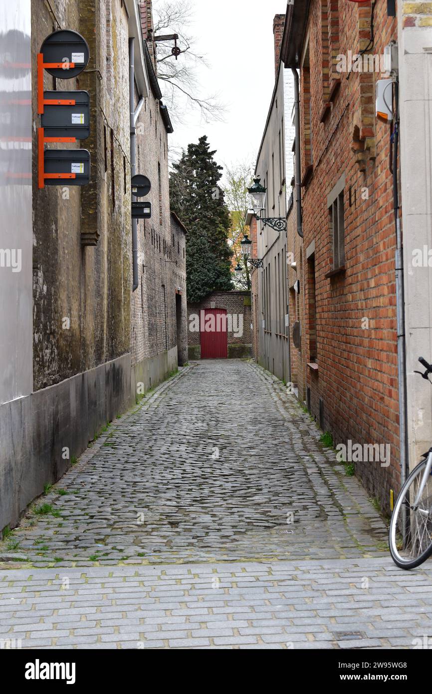 A small picturesque cobblestone alley in the medieval city centre of ...