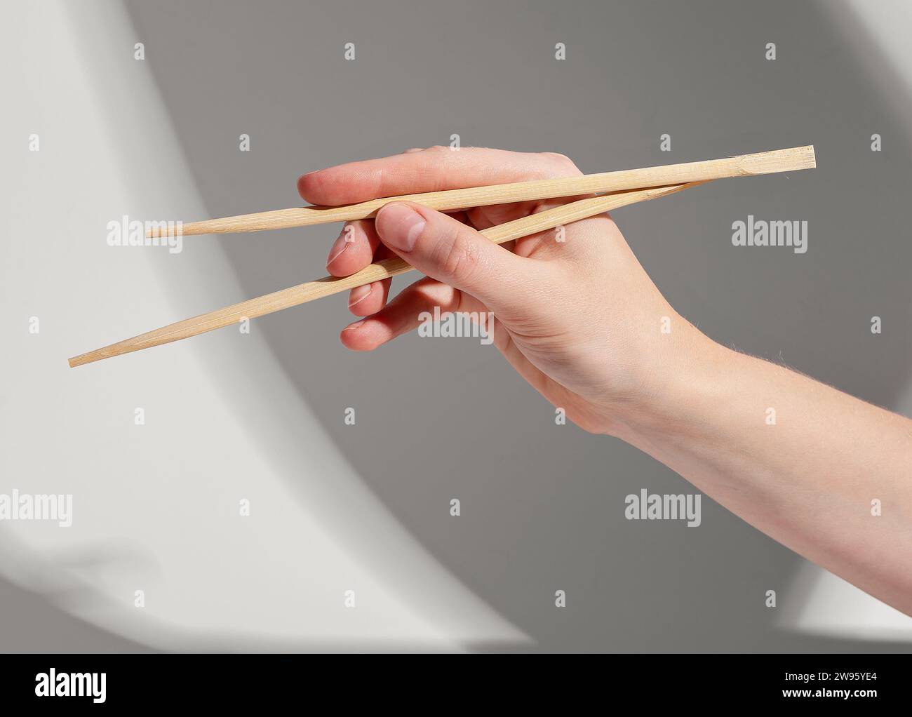 Wooden chopsticks in hands. Chinese food sticks Stock Photo - Alamy