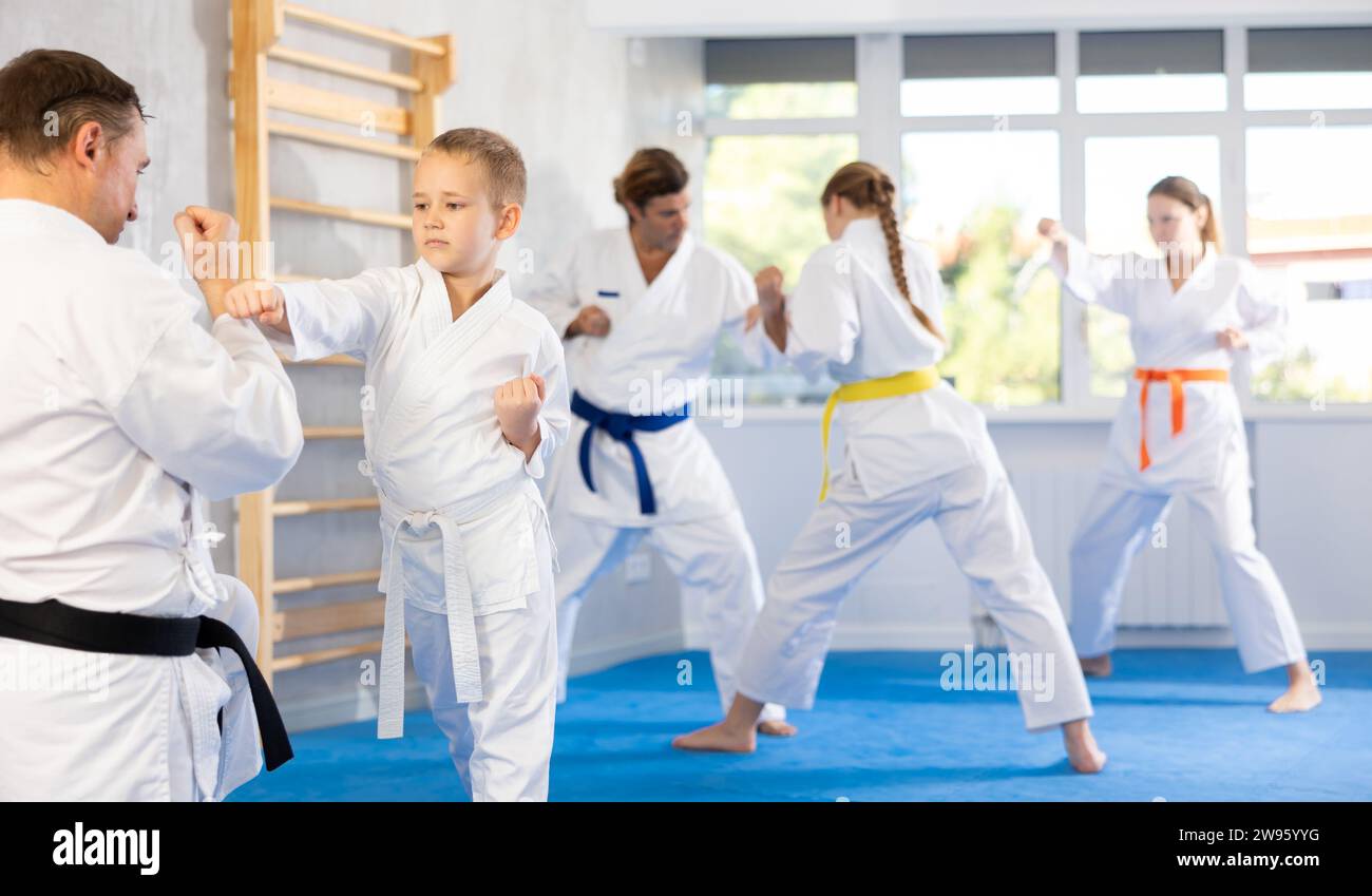 Boy is paired with man teacher to learn how to strike and rehearses ...