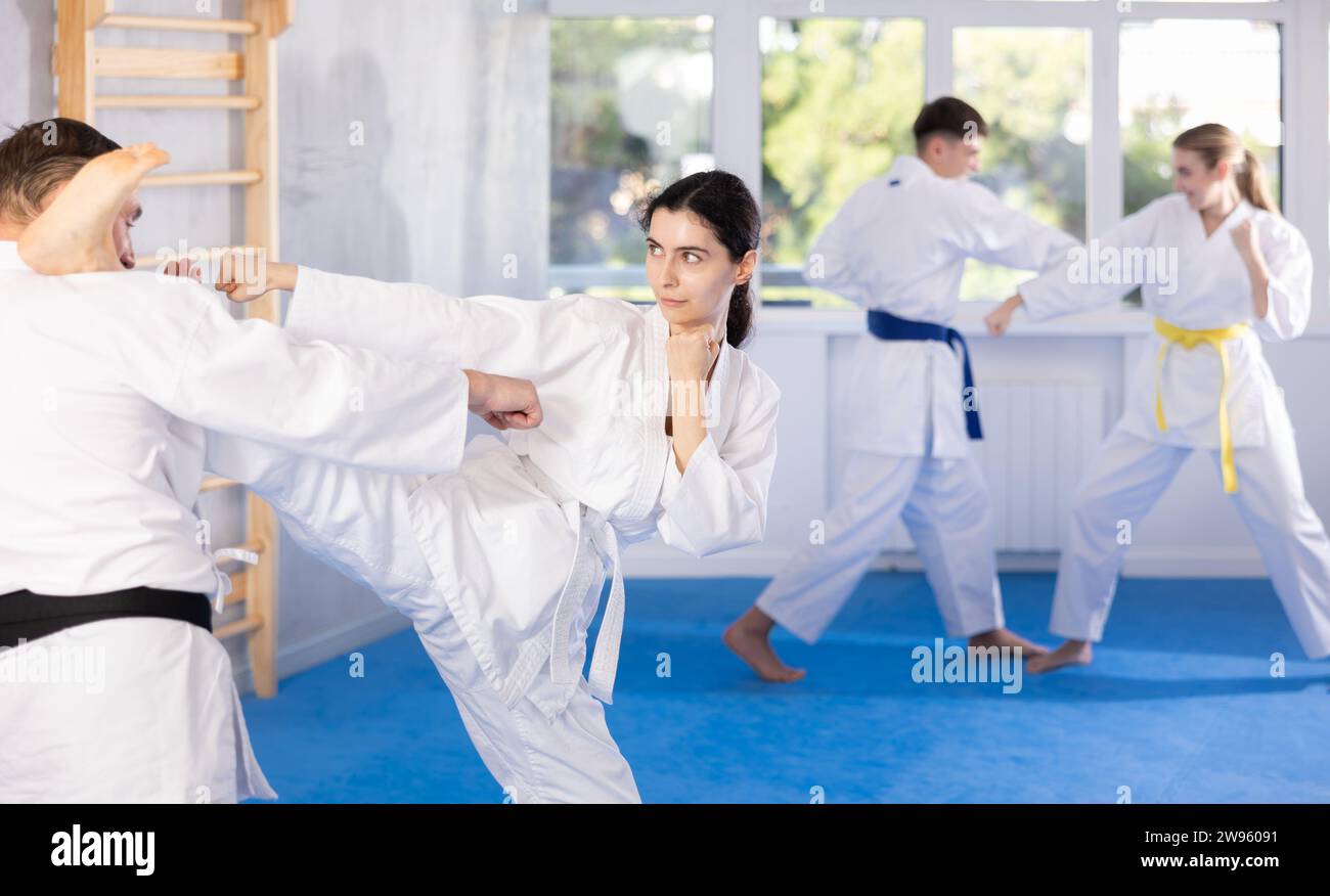 Young female attendee of karate classes fighting with middle-aged man ...