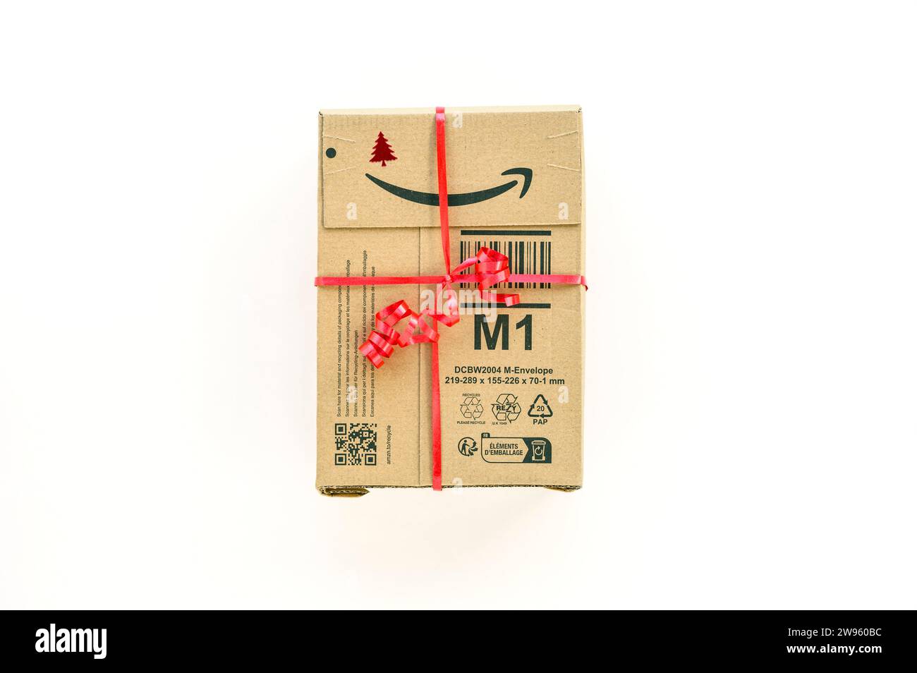 Christmas gift parcel in it's original packaging with a red ribbon tied ...