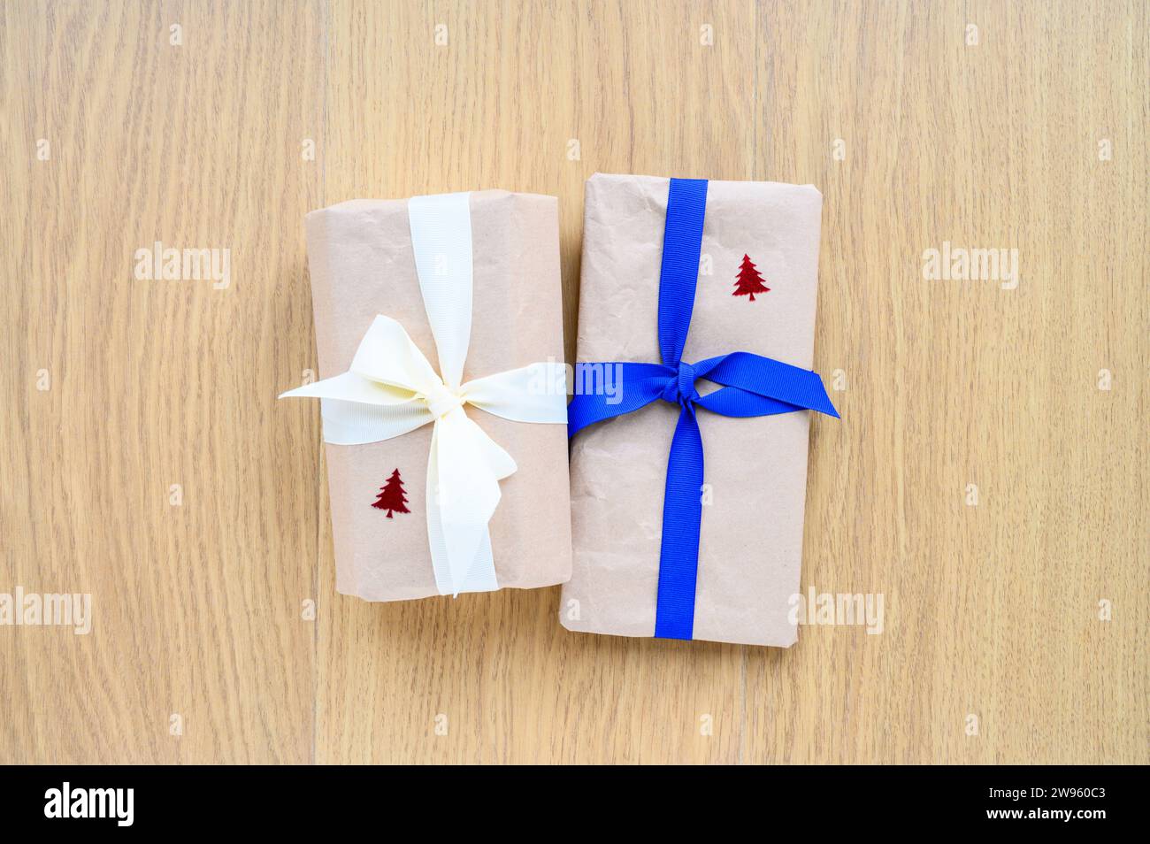 Christmas gift parcels wrapped in brown paper and tied up with a blue ...