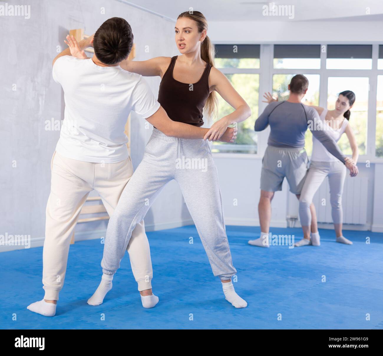 Woman practices blows to the head of a male attacker during self ...