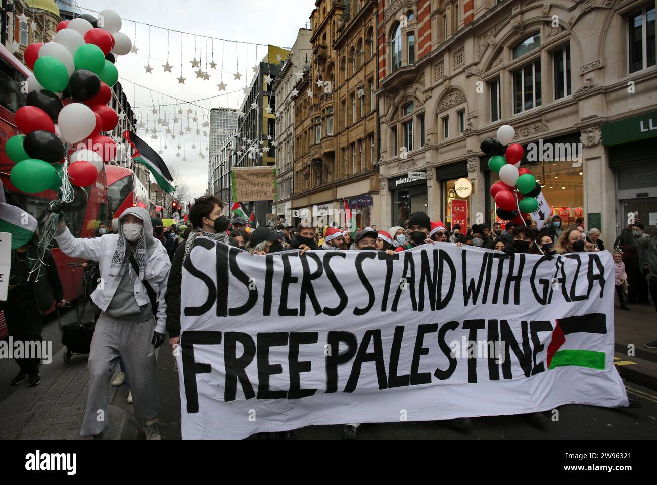 Protesters march down Oxford Street behind a banner saying ’Sisters ...