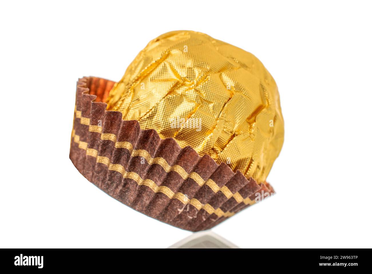 One chocolate candy with a nut in a paper wrapper, macro, isolated on a ...
