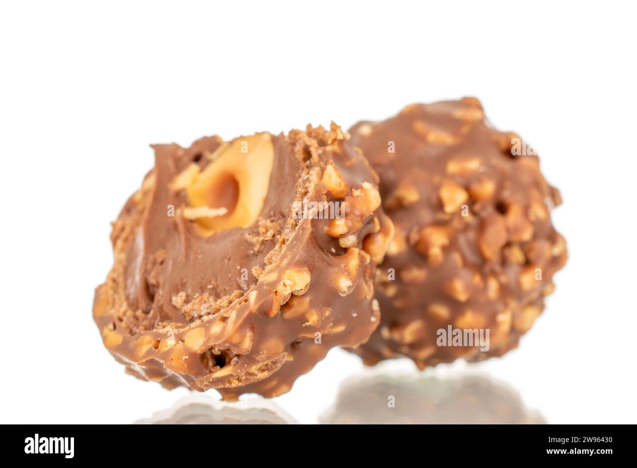 Two halves of a chocolate candy with a nut, macro, isolated on a white ...