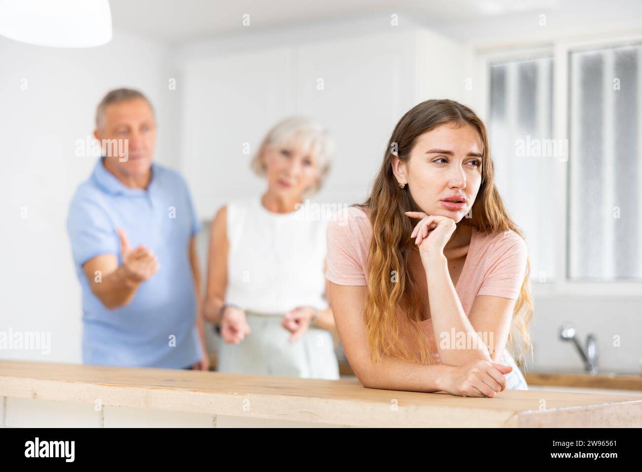 Elderly parents scold adult daughter in kitchen Stock Photo - Alamy