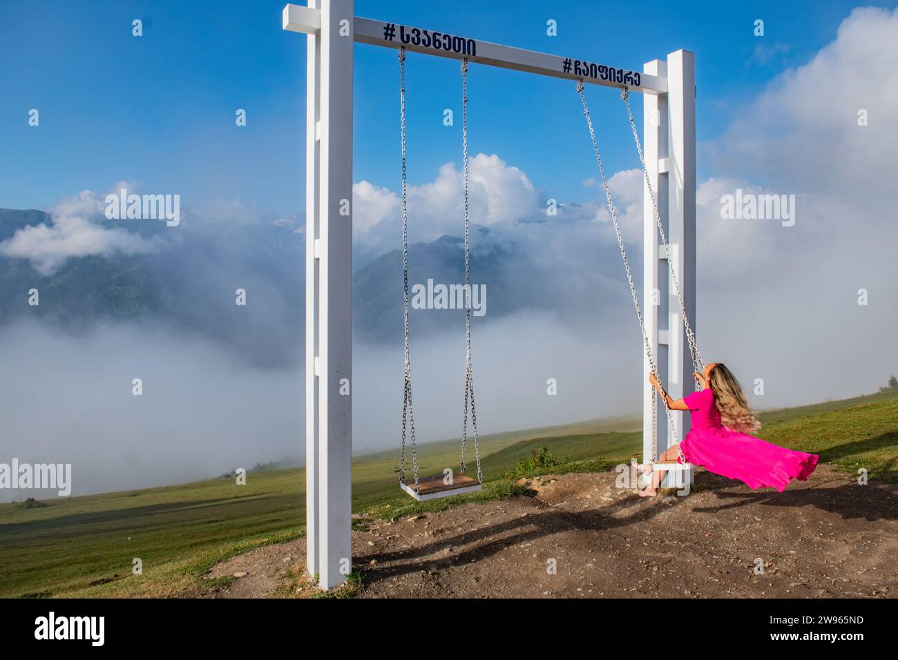 Taking a swing serenade by a girl in a pink dress on a swing Stock ...