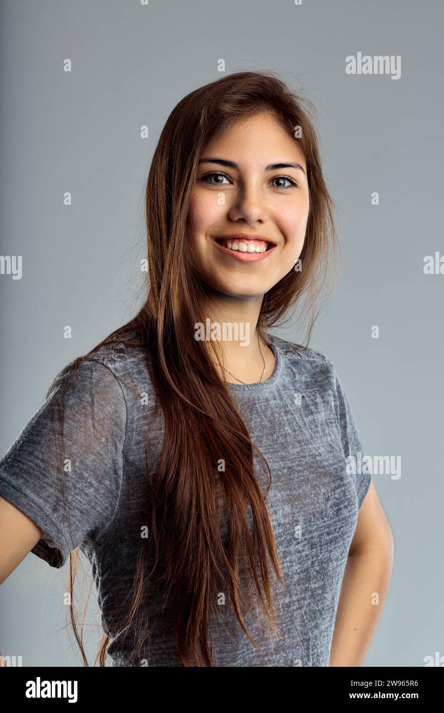 Confident young adult with brown hair and a warm smile poses for a casual photograph Stock Photo ...