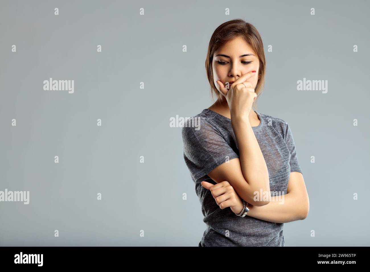 pensive mood envelops her as she contemplates, the world fading behind ...