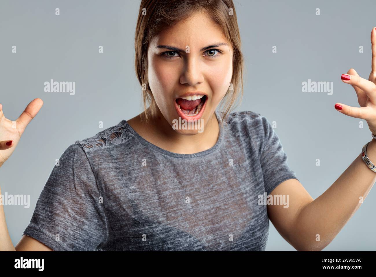 Young woman makes a roaring gesture, expressing ferocity and playful ...