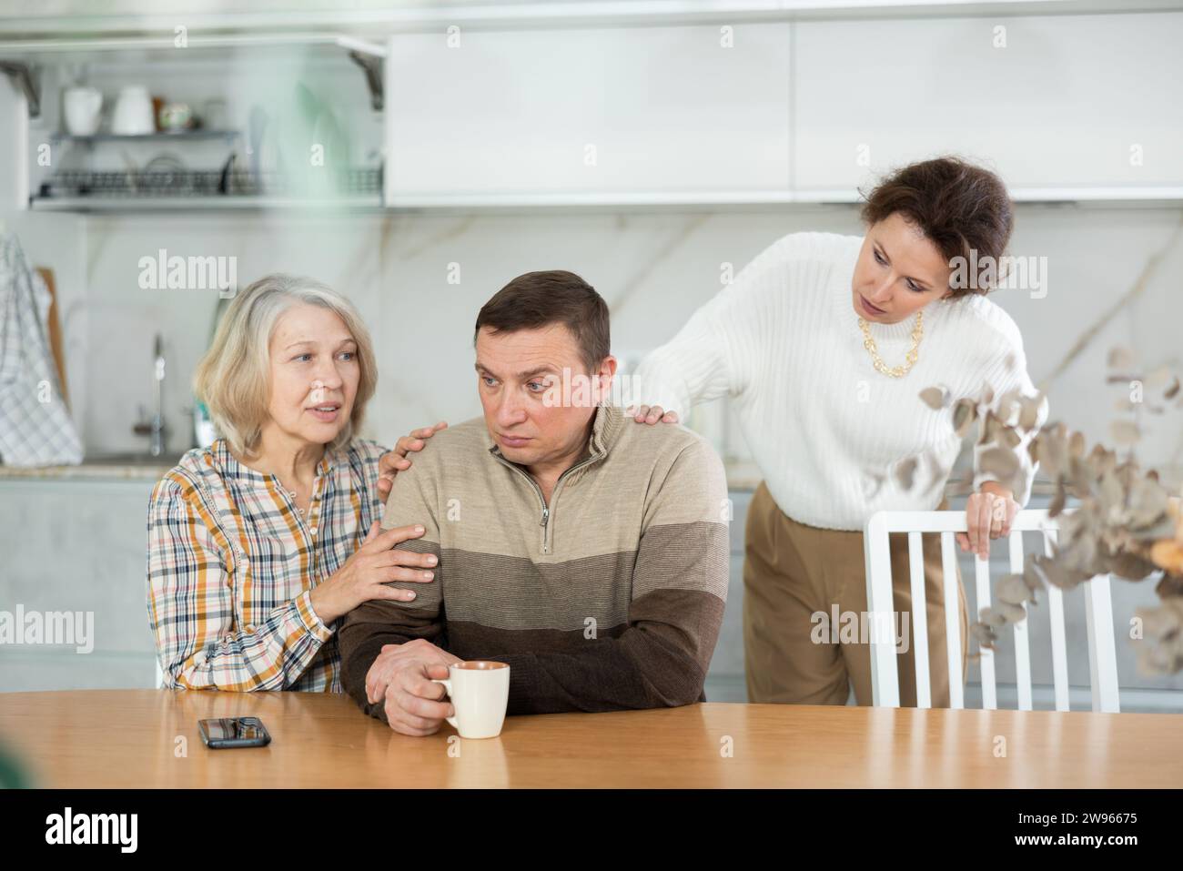 Family members quarreling in the kitchen and old woman trying to calm ...