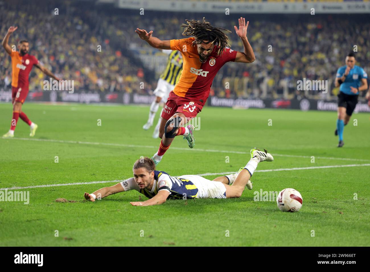 Galatasaray's Sacha Boey jumps over Fenerbahce's Miguel Crespo for the ...