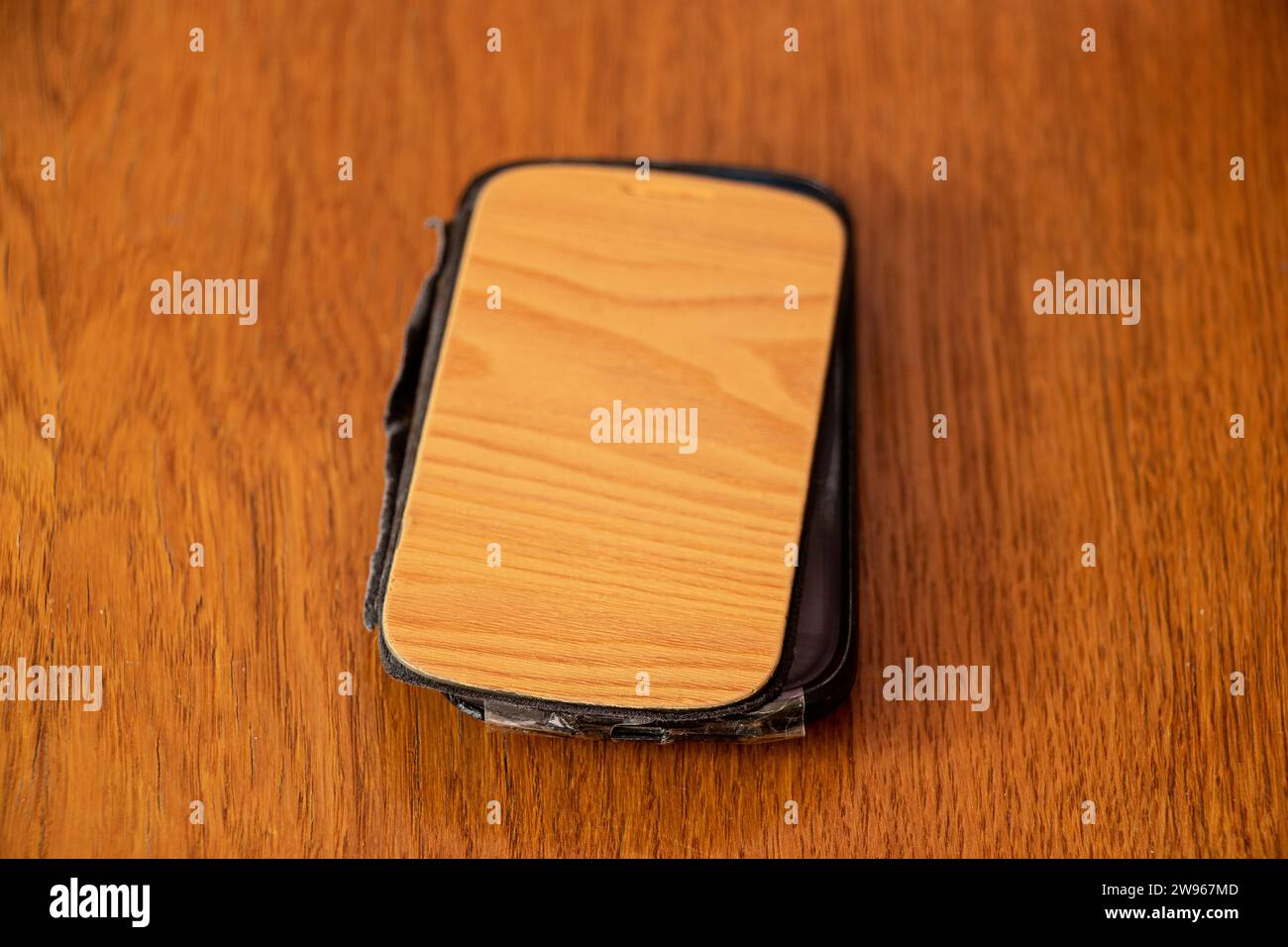 There is an old touch mobile phone covered with tape on the table ...