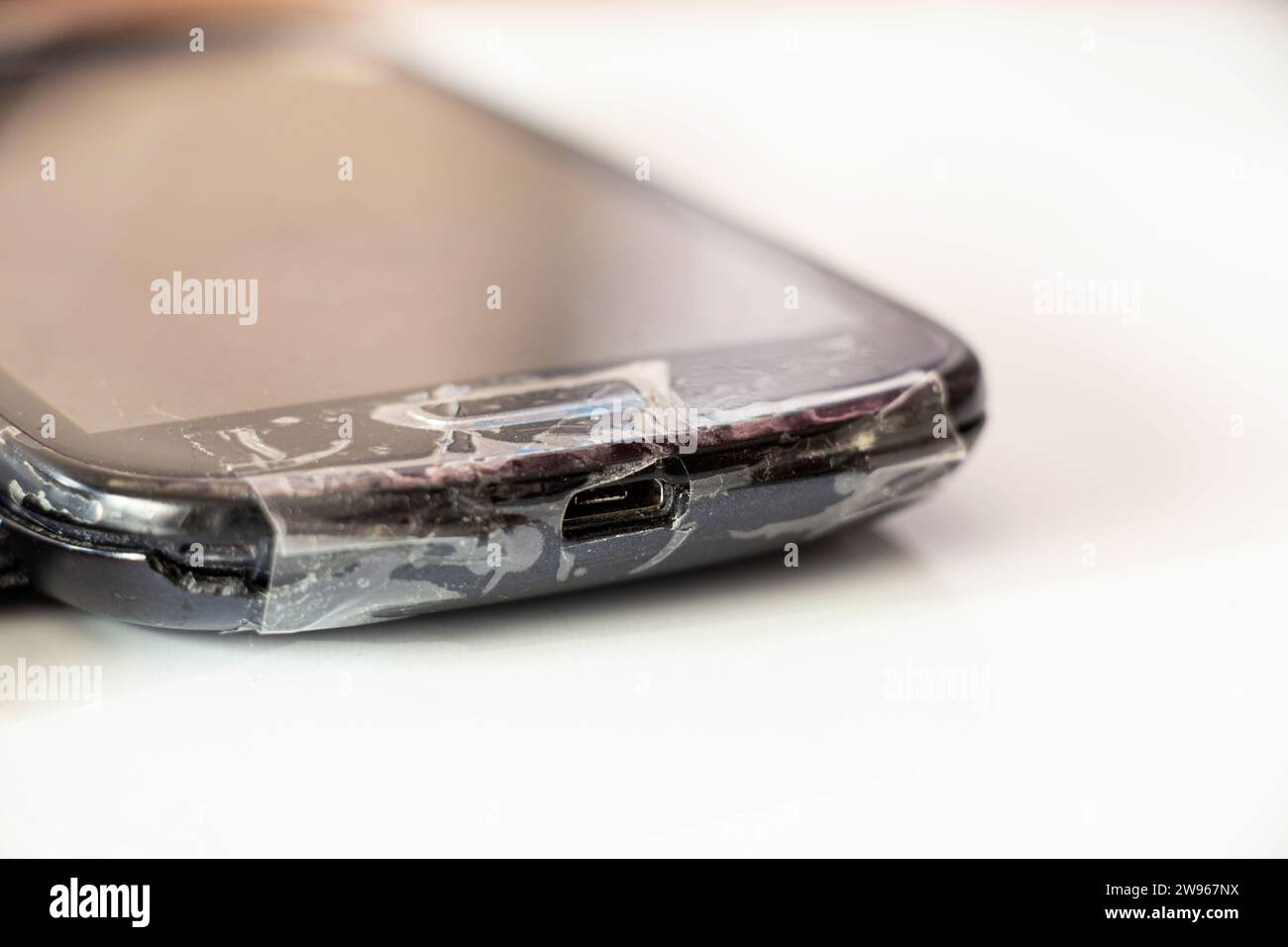 There is an old touch mobile phone covered with tape on the table ...