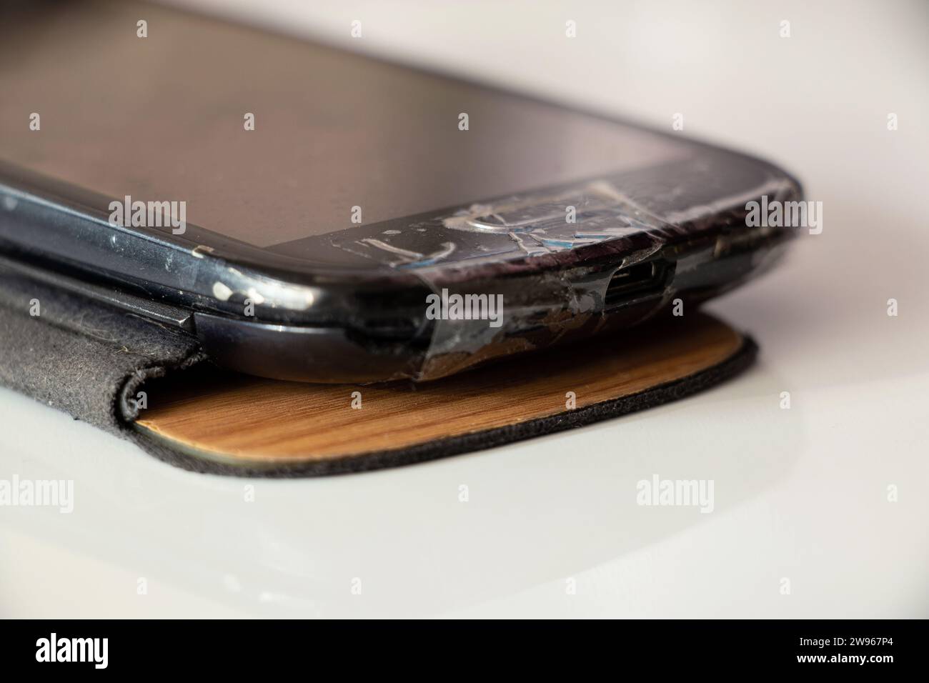 There is an old touch mobile phone covered with tape on the table ...