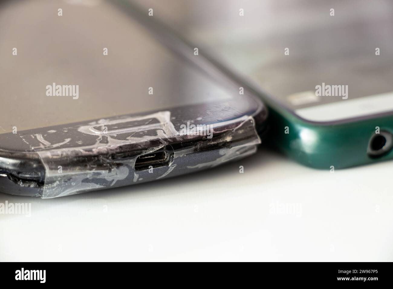 There is an old touch mobile phone covered with tape on the table ...