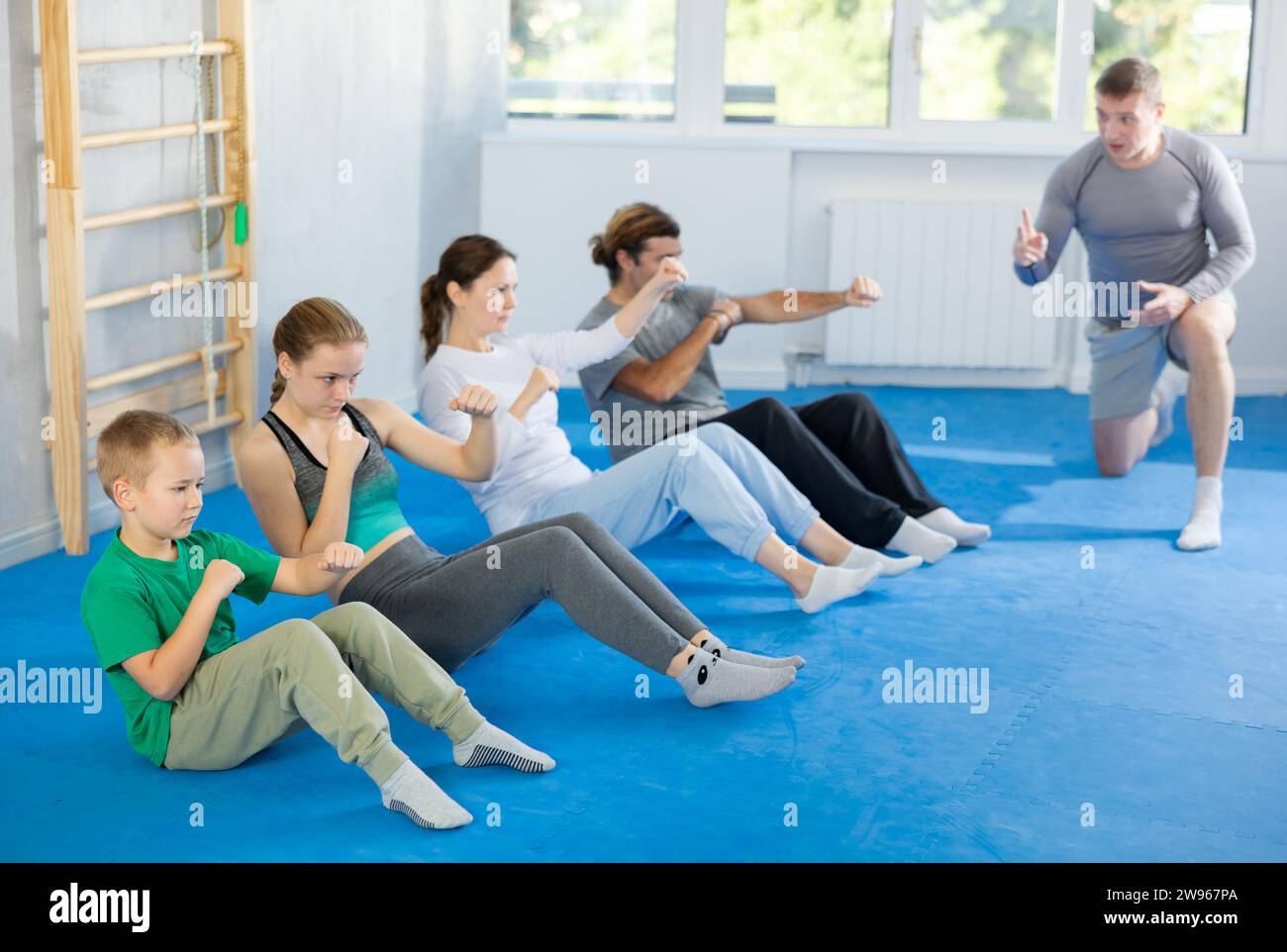 Family pupils performs exercises to strengthen press and improve ...