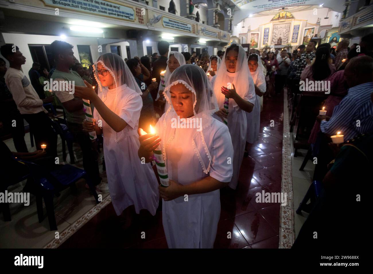 Nuns hold candles during the Christmas Eve mass at Graha Maria Annai ...