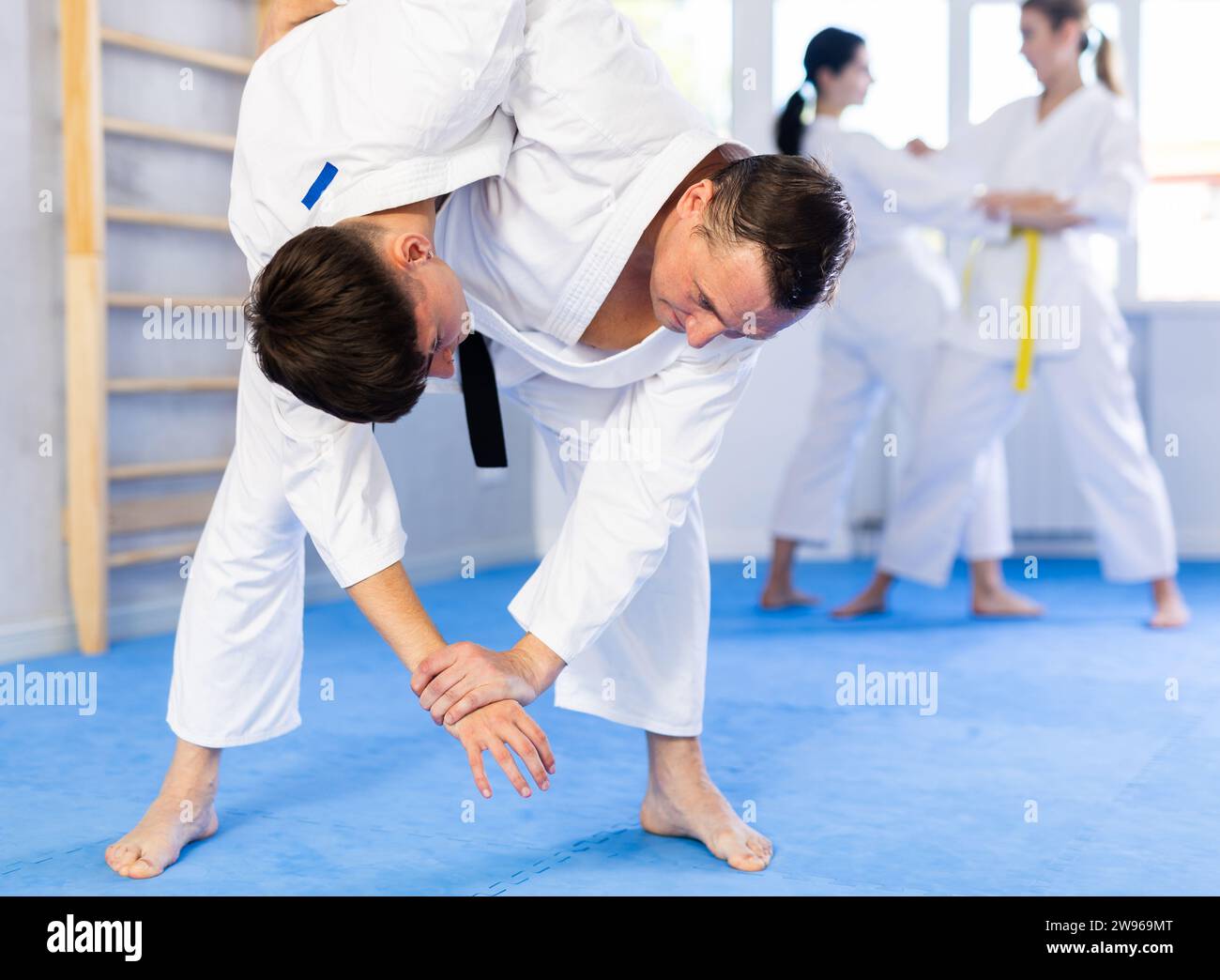 Skillful middle-aged and young men applying throwing technique during ...
