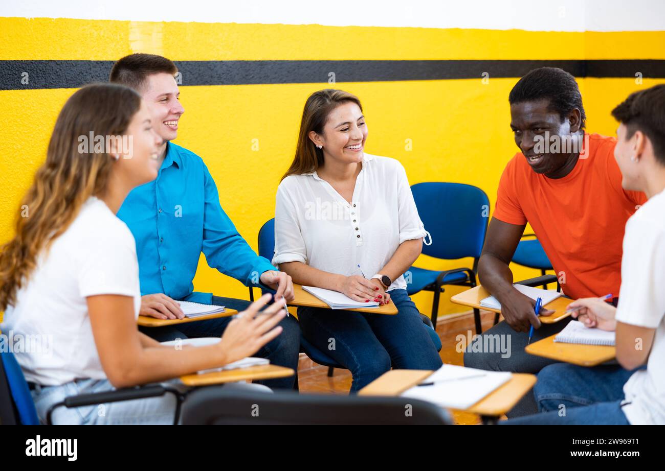 Happy adult university students brainstorming while preparing for exam ...