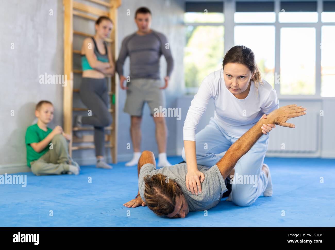 At self-defense training, trainer teaches woman technique of grabbing ...