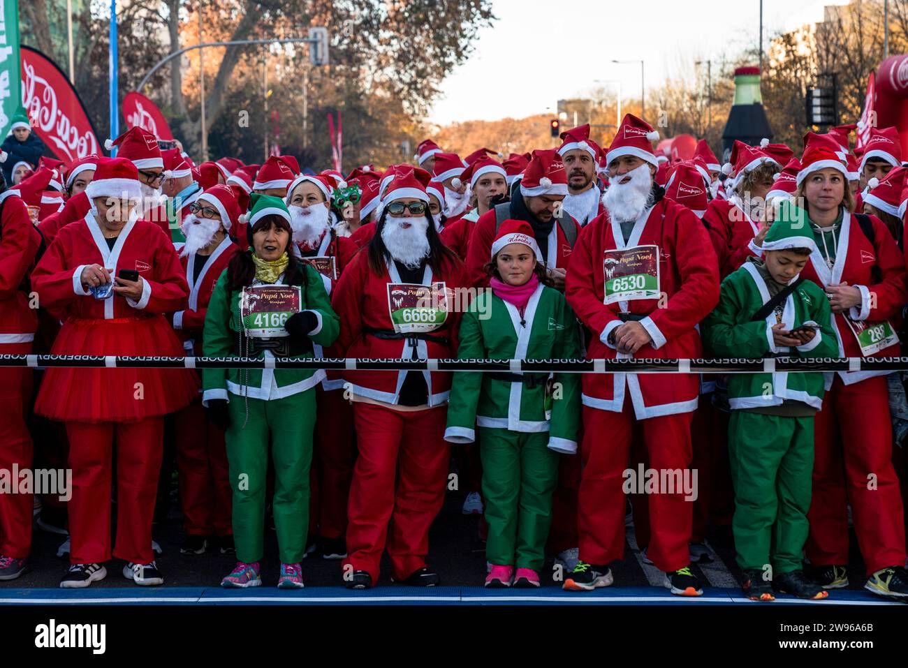 Thousands of people dressed as Santa Claus stand at the starting line ...