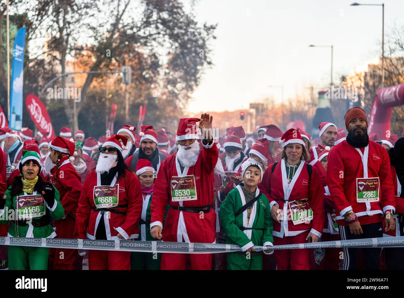 Thousands of people dressed as Santa Claus stand at the starting line ...