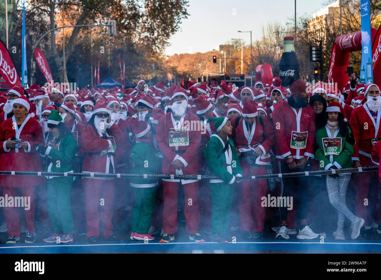 Thousands of people dressed as Santa Claus stand at the starting line ...
