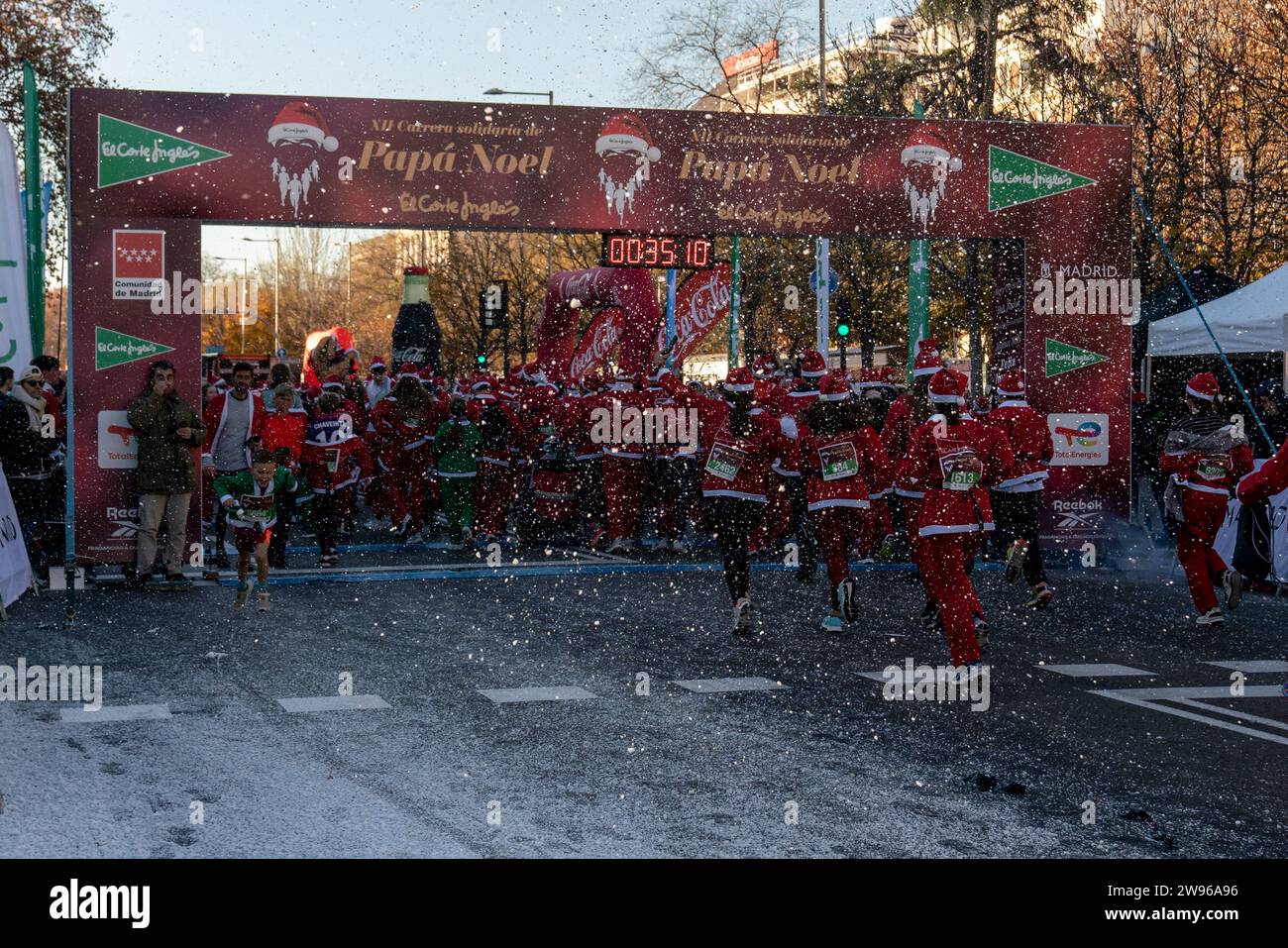 Participants dressed as Santa Claus arrive at the finish line during ...