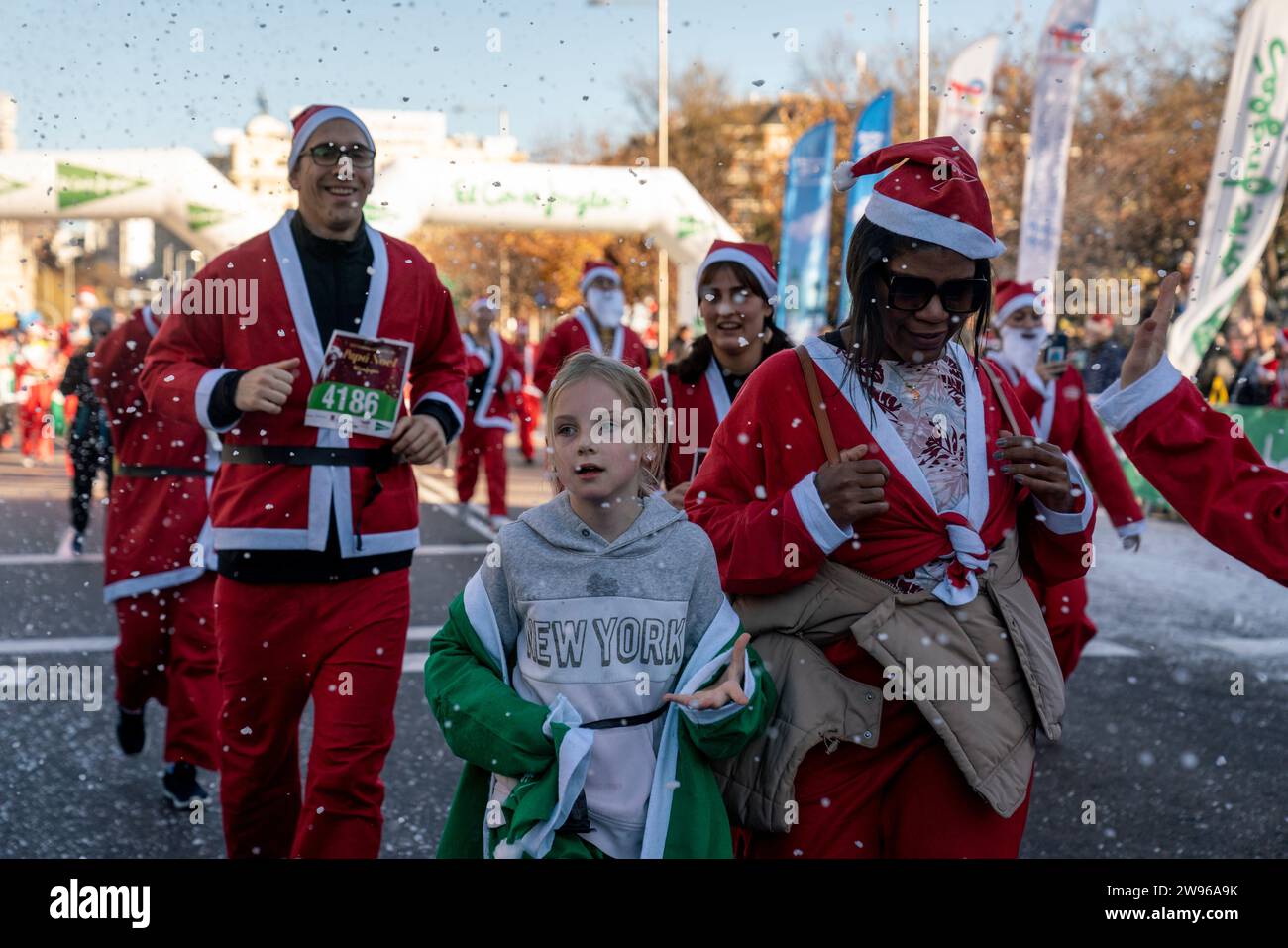 Participants dressed as Santa Claus arrive at the finish line during ...