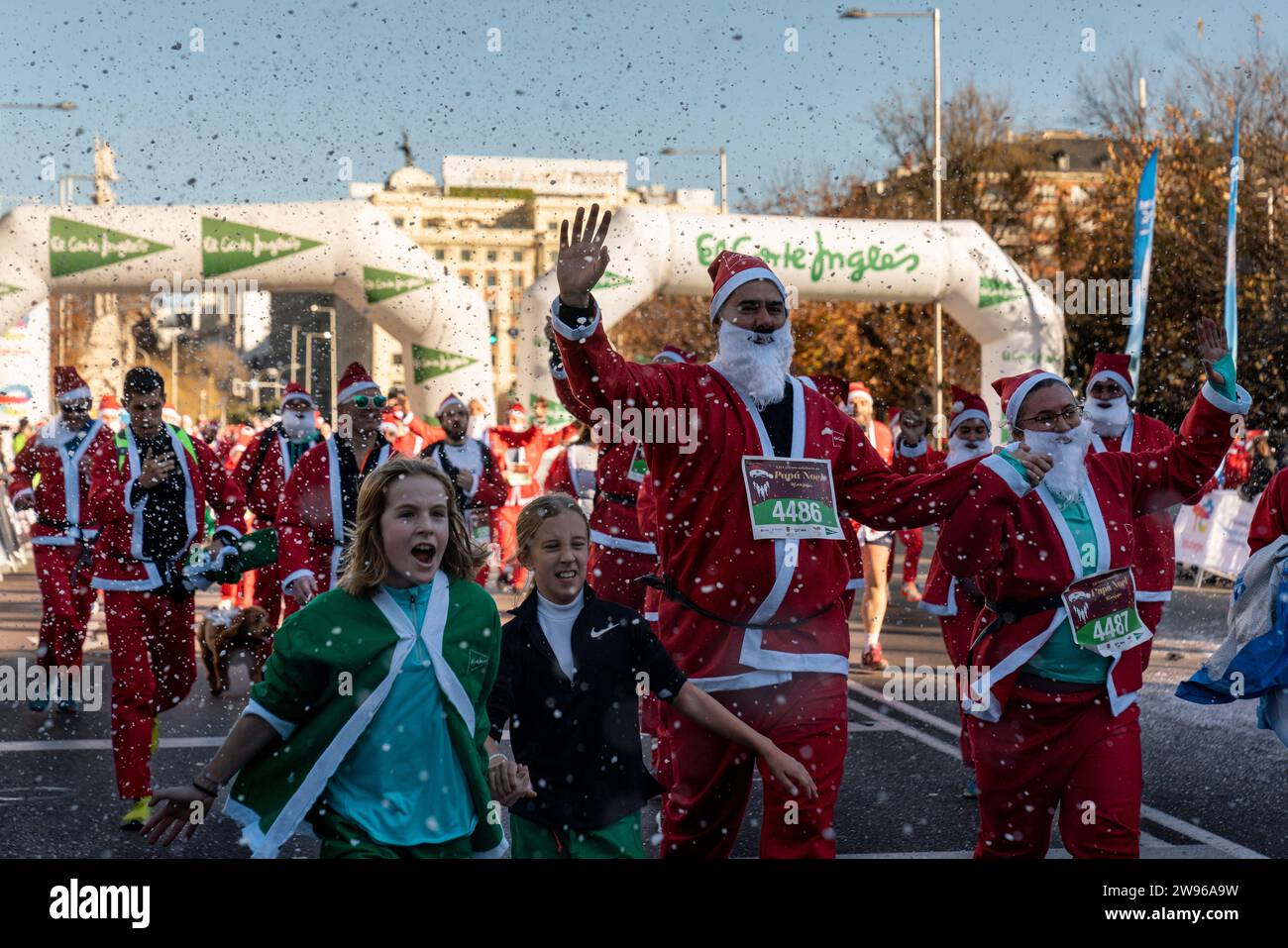 Participants dressed as Santa Claus arrive at the finish line during ...