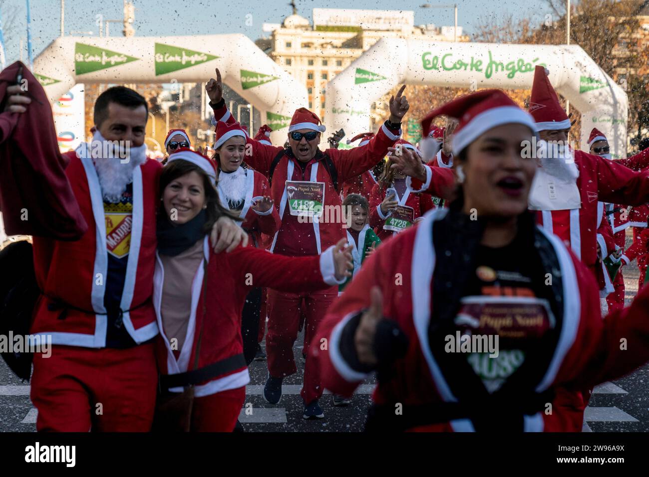 Participants dressed as Santa Claus arrive at the finish line during ...