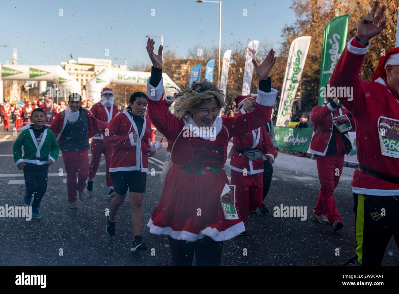 Participants dressed as Santa Claus arrive at the finish line during ...