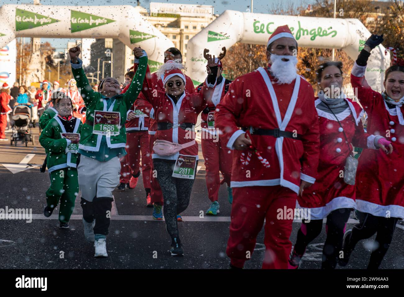 Participants dressed as Santa Claus arrive at the finish line during ...